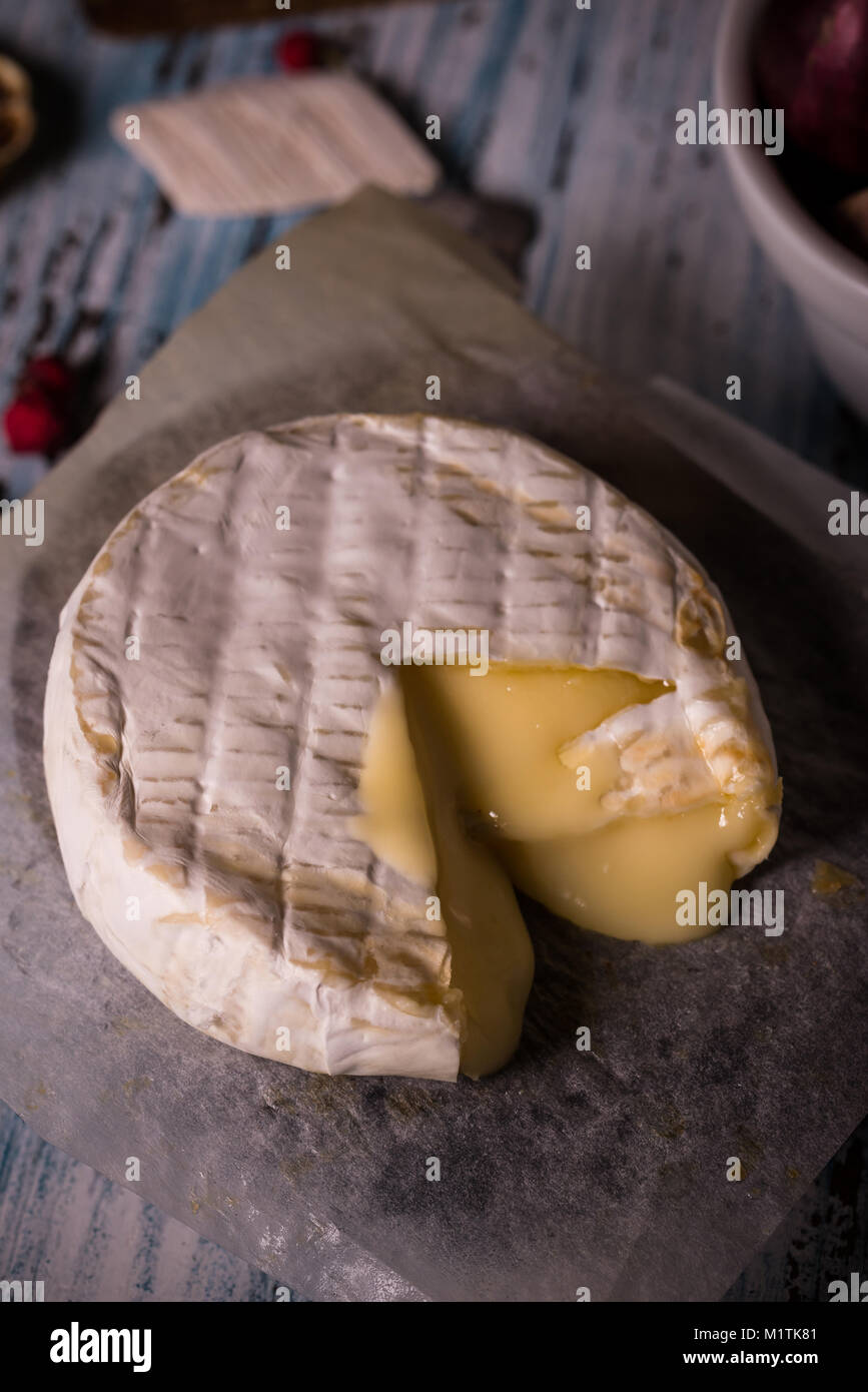 Vertical photo of single grilled camembert cheese. The cheese is whole ...