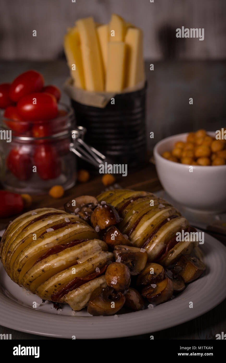 Vertical photo with two roasted and sliced whole potatoes. The cuts are ...