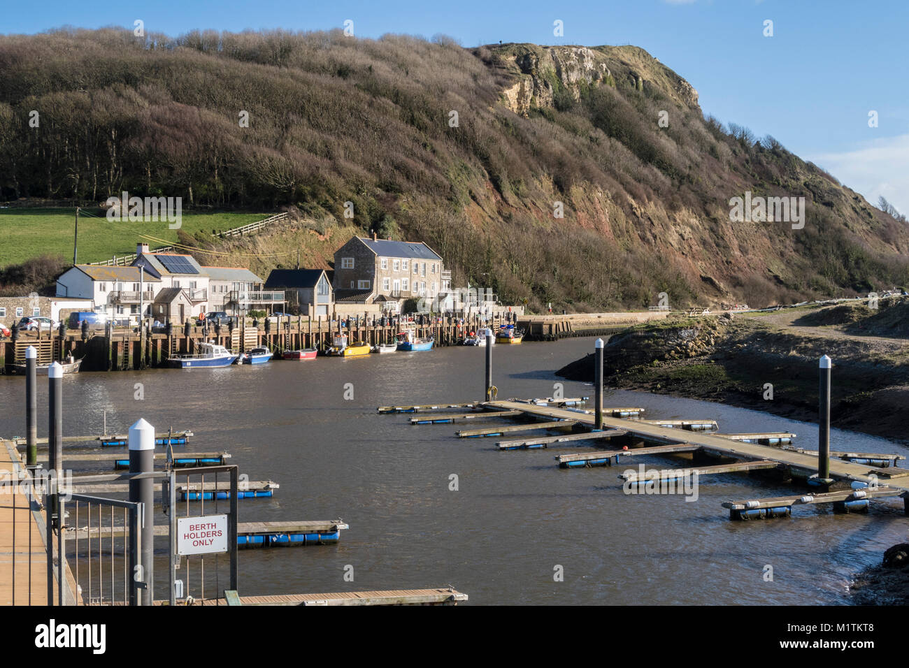 Empty berths at Axmouth Harbour, where the River Axe reaches the sea at ...