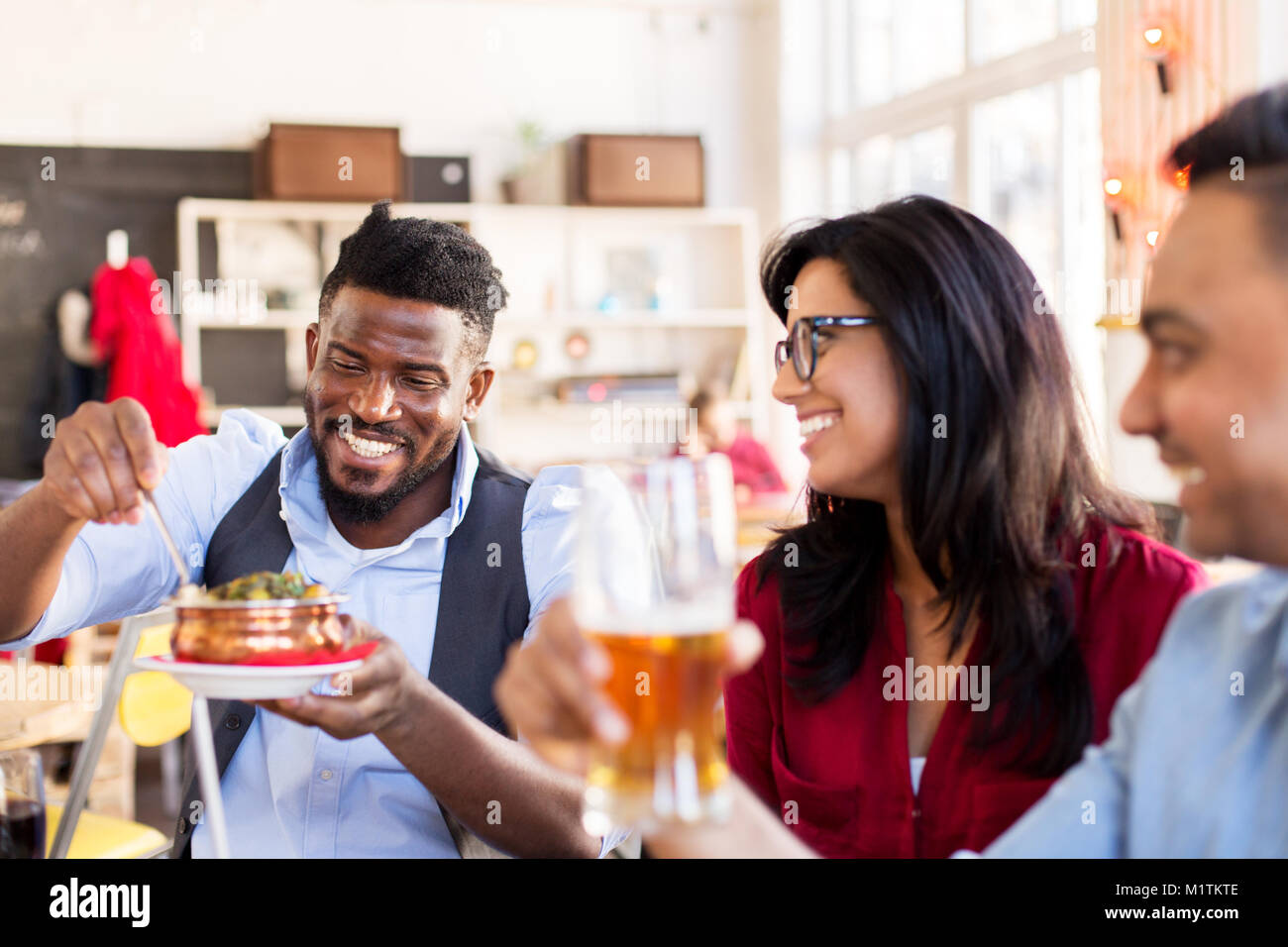 happy friends eating at restaurant Stock Photo - Alamy