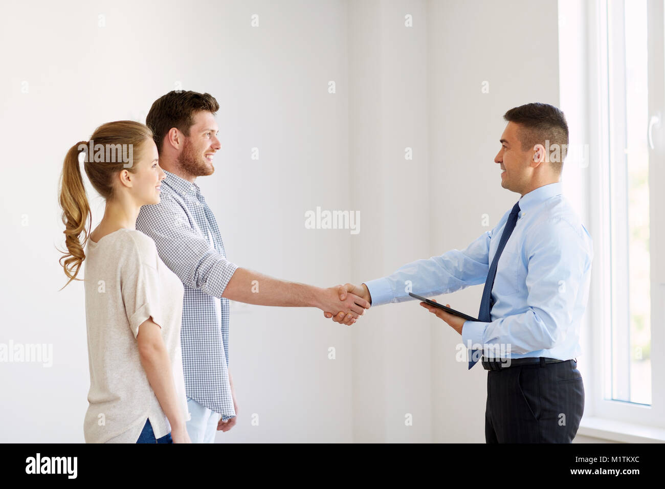 man and realtor shaking hands at new home Stock Photo - Alamy