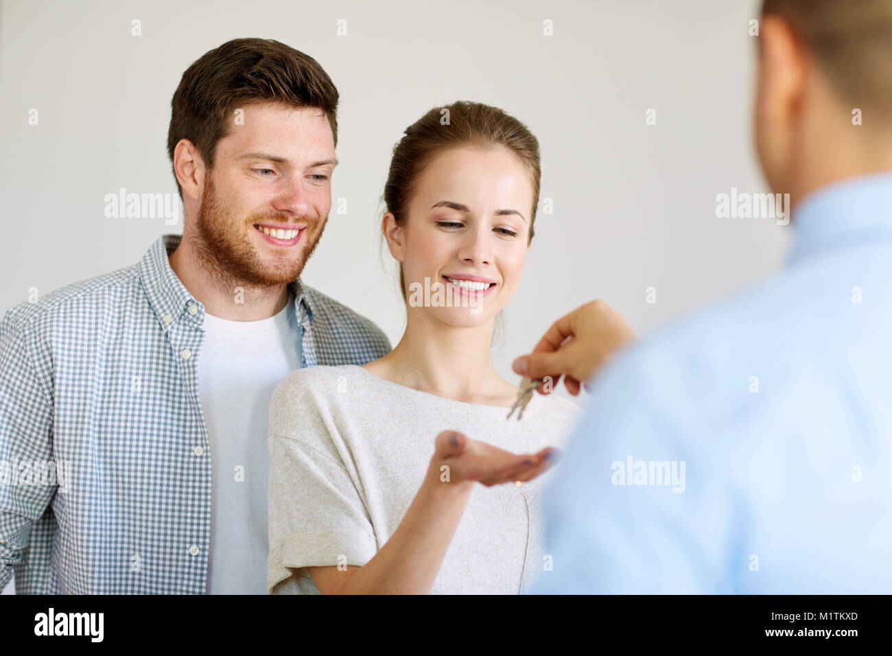 realtor giving keys from new home to happy couple Stock Photo - Alamy