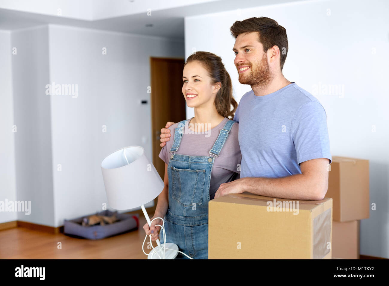 couple with boxes and lamp moving to new home Stock Photo - Alamy
