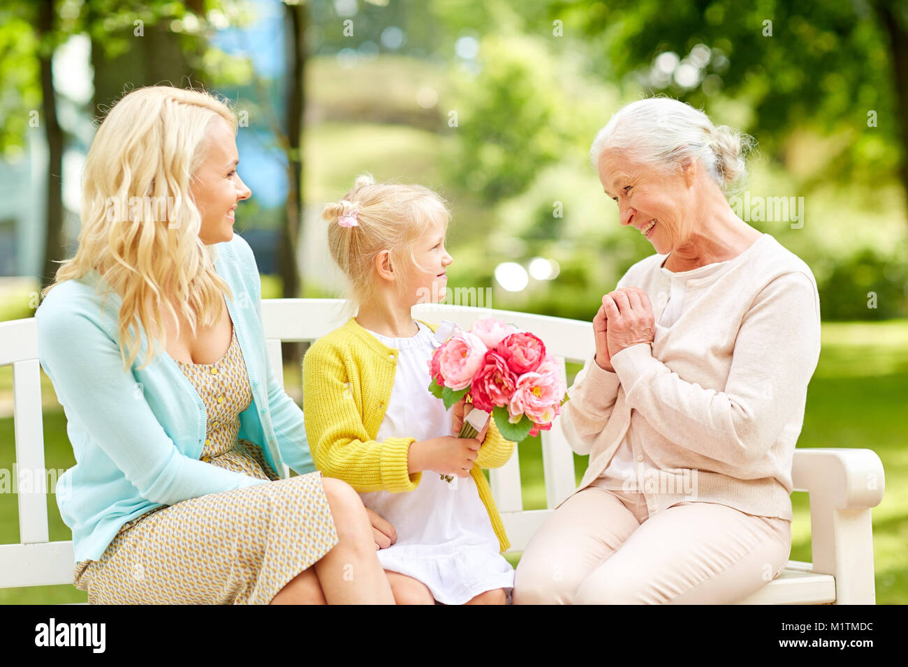 happy family giving flowers to grandmother at park Stock Photo - Alamy
