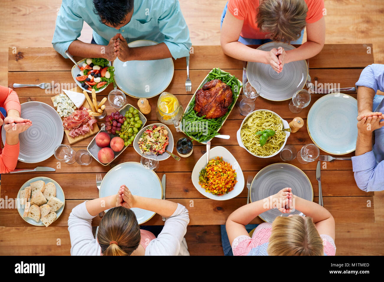 group of people at table praying before meal Stock Photo - Alamy