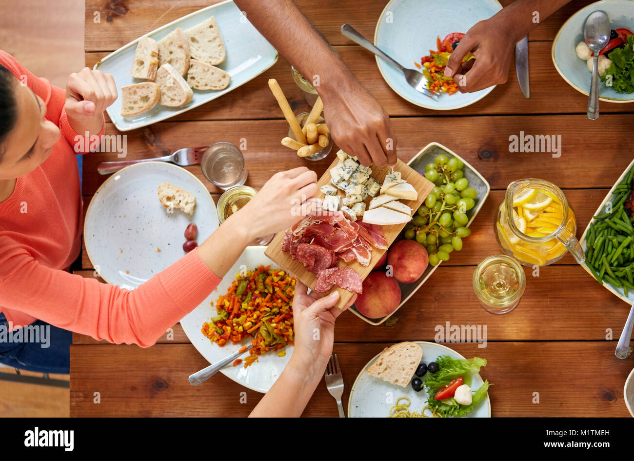 group of people eating at table with food Stock Photo - Alamy