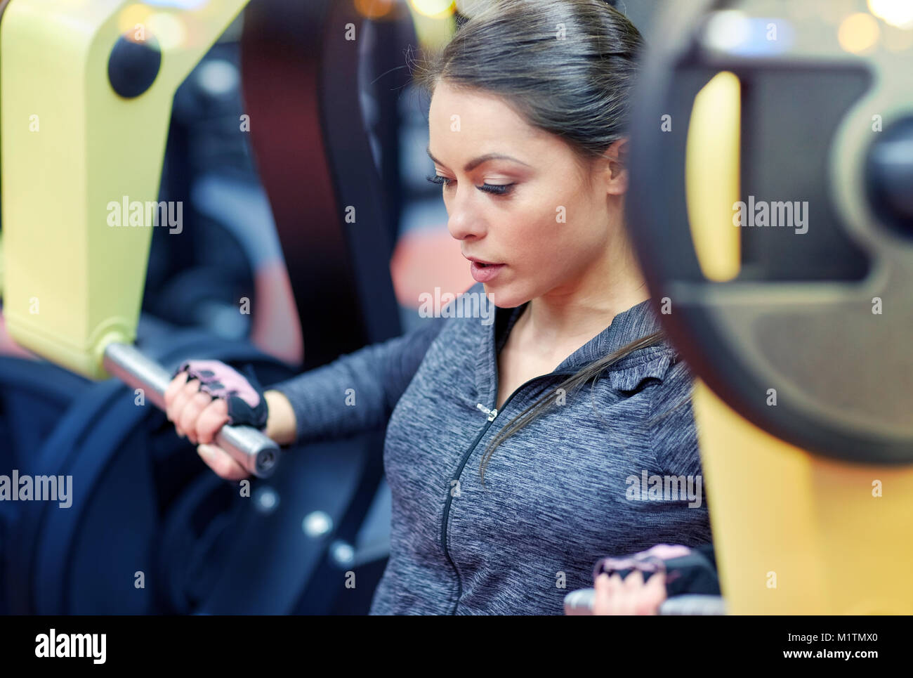 woman flexing muscles on chest press gym machine Stock Photo - Alamy