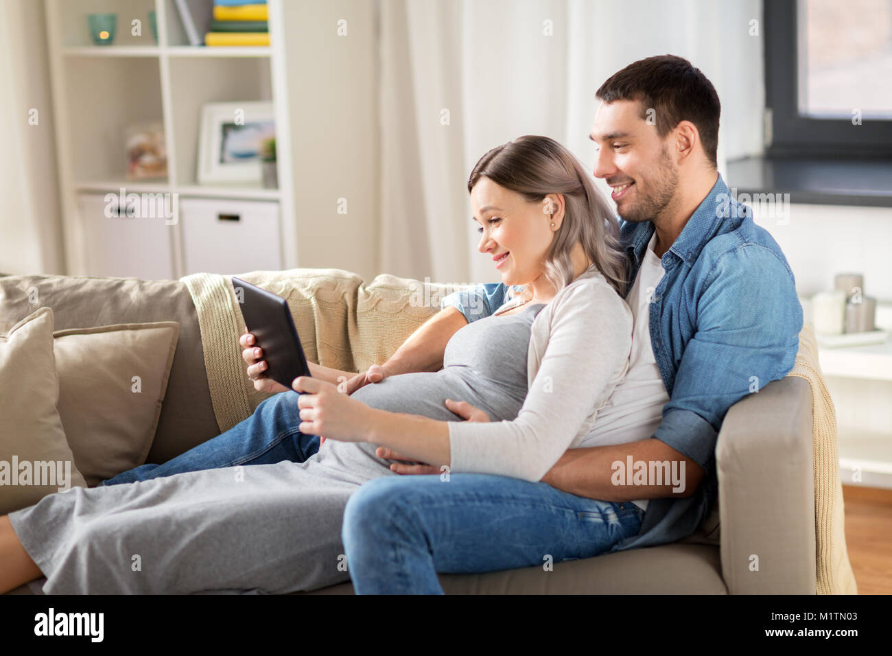 Happy pregnant couple tablet hi-res stock photography and images - Alamy