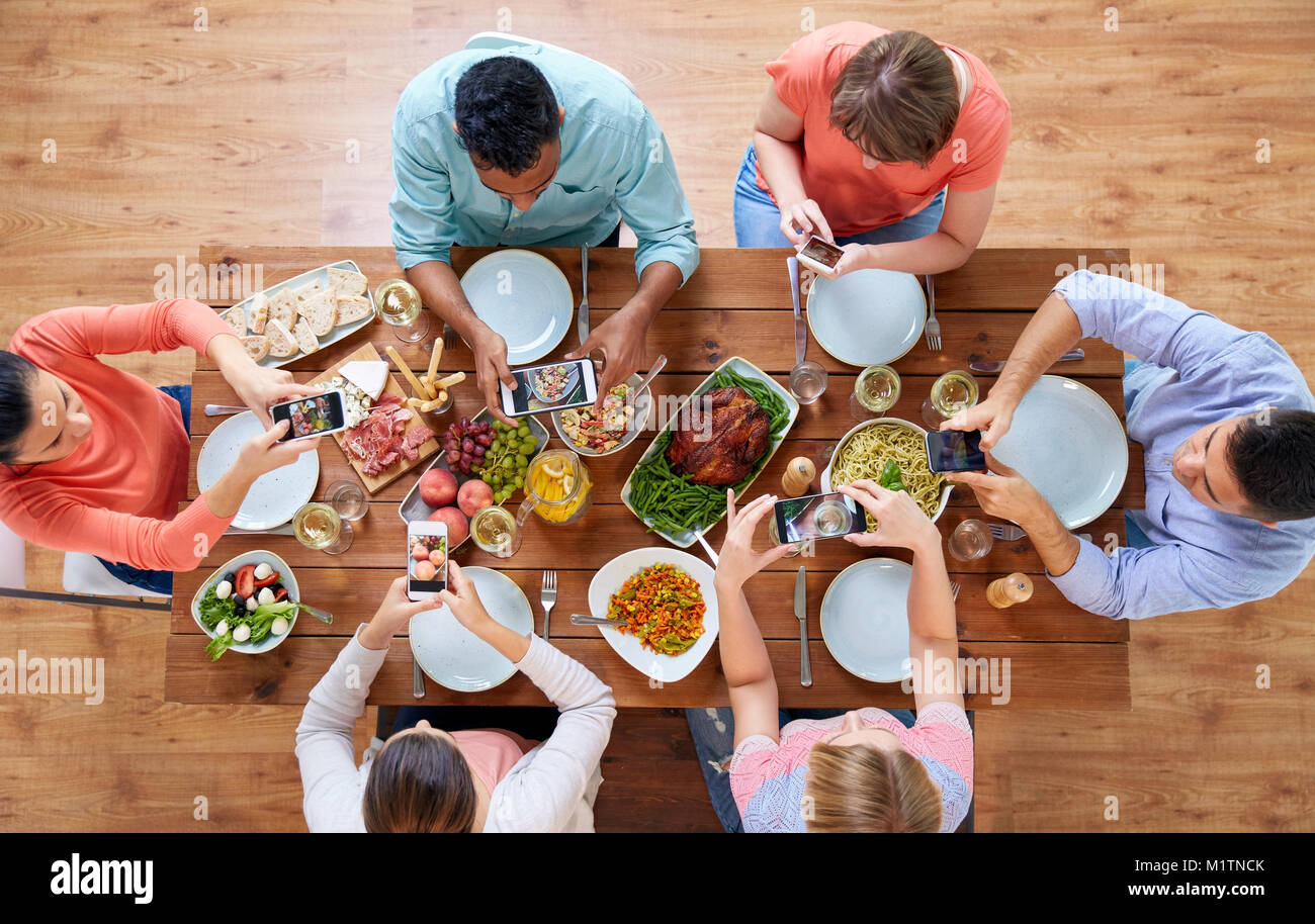women with smartphones eating food at table Stock Photo - Alamy