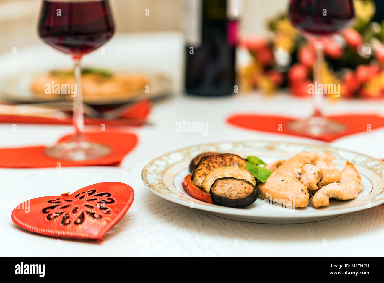 Romantic dinner for two with wine, heart, flowers Stock Photo - Alamy