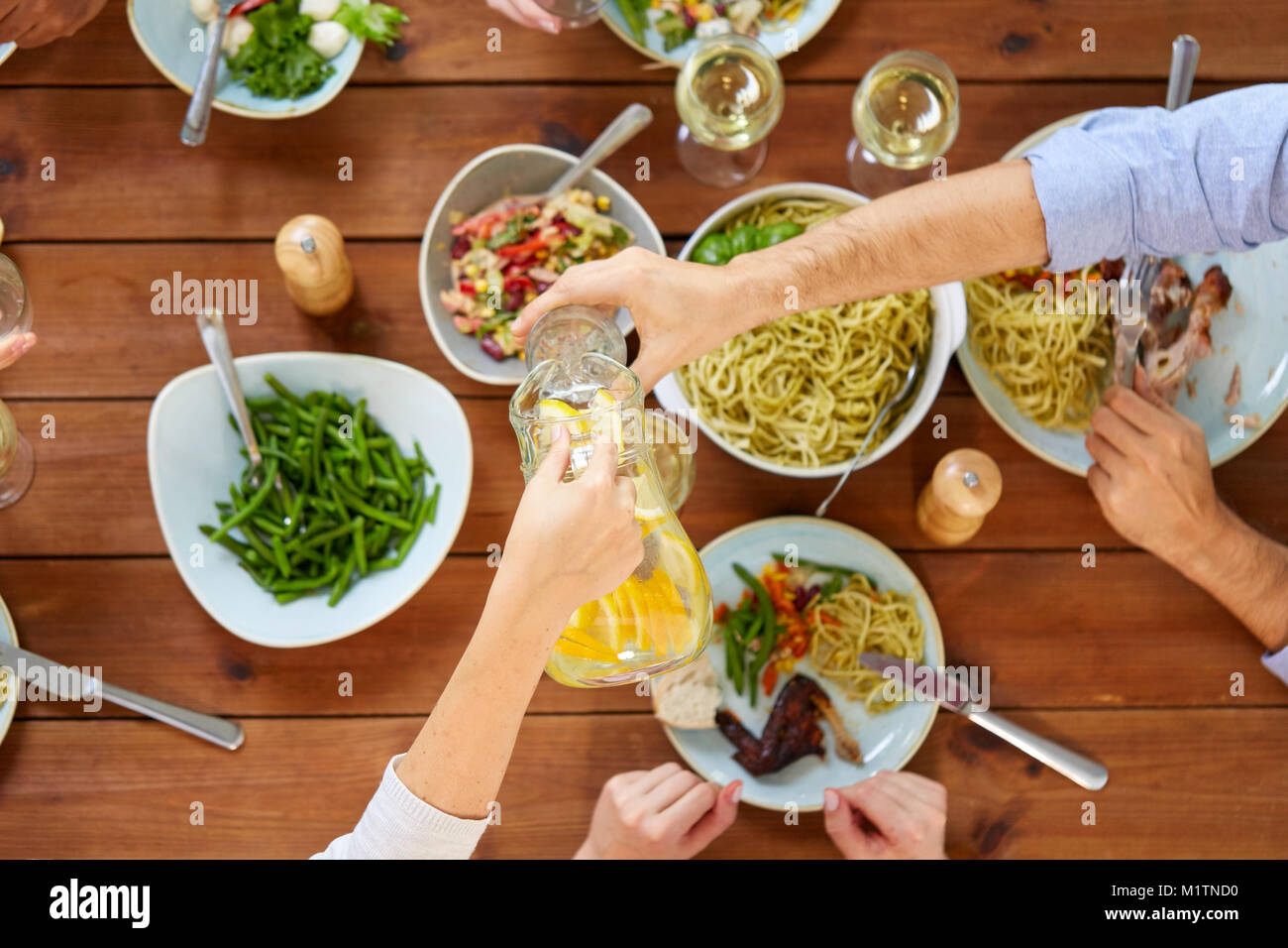people at table with food eating and drinking Stock Photo - Alamy