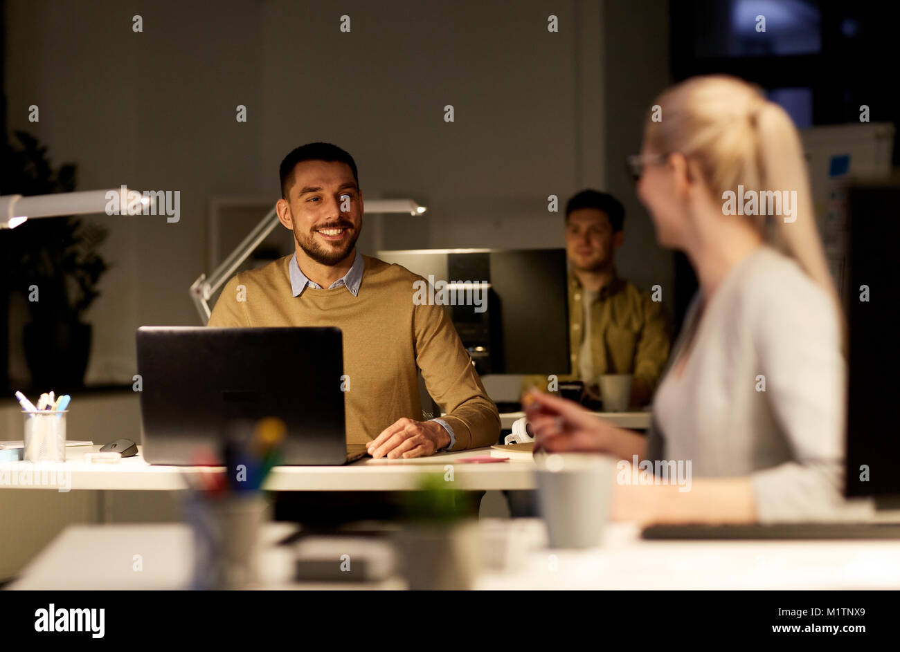 coworkers with laptop working late at office Stock Photo - Alamy