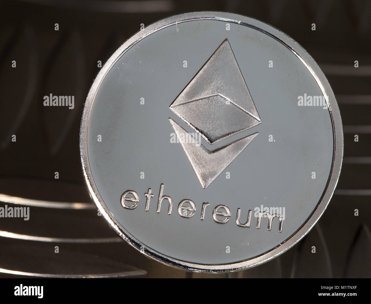 A physical silver Ethereum (ETH) crypto coin token on aluminium chequer ...