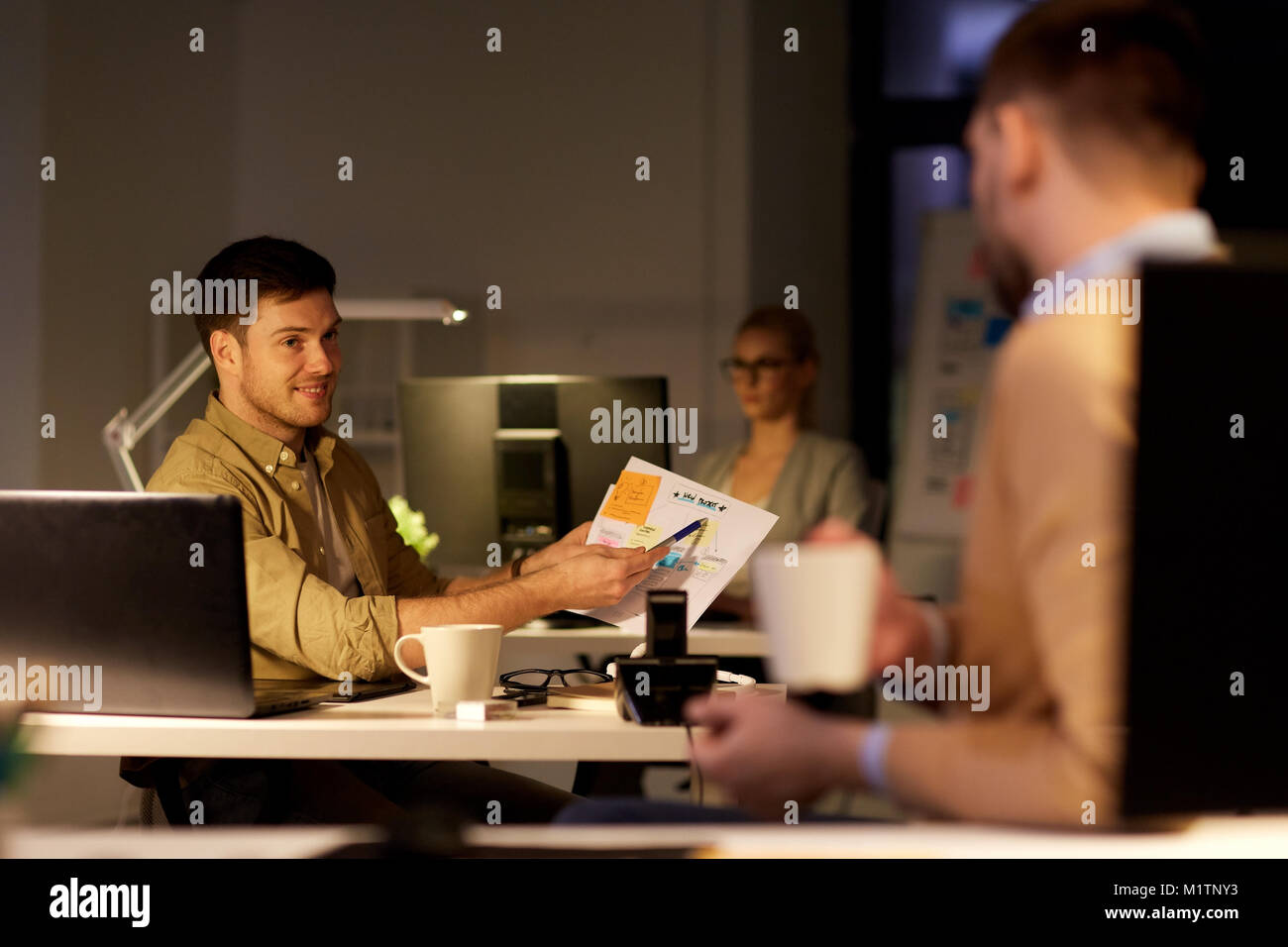 colleagues discussing project late in office Stock Photo - Alamy