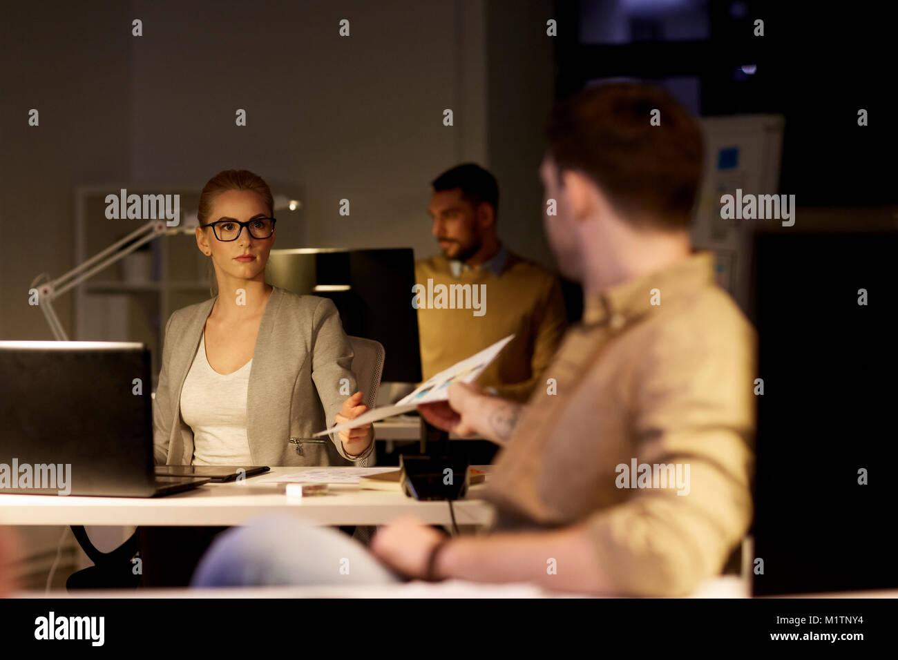 coworkers with papers working late at office Stock Photo - Alamy