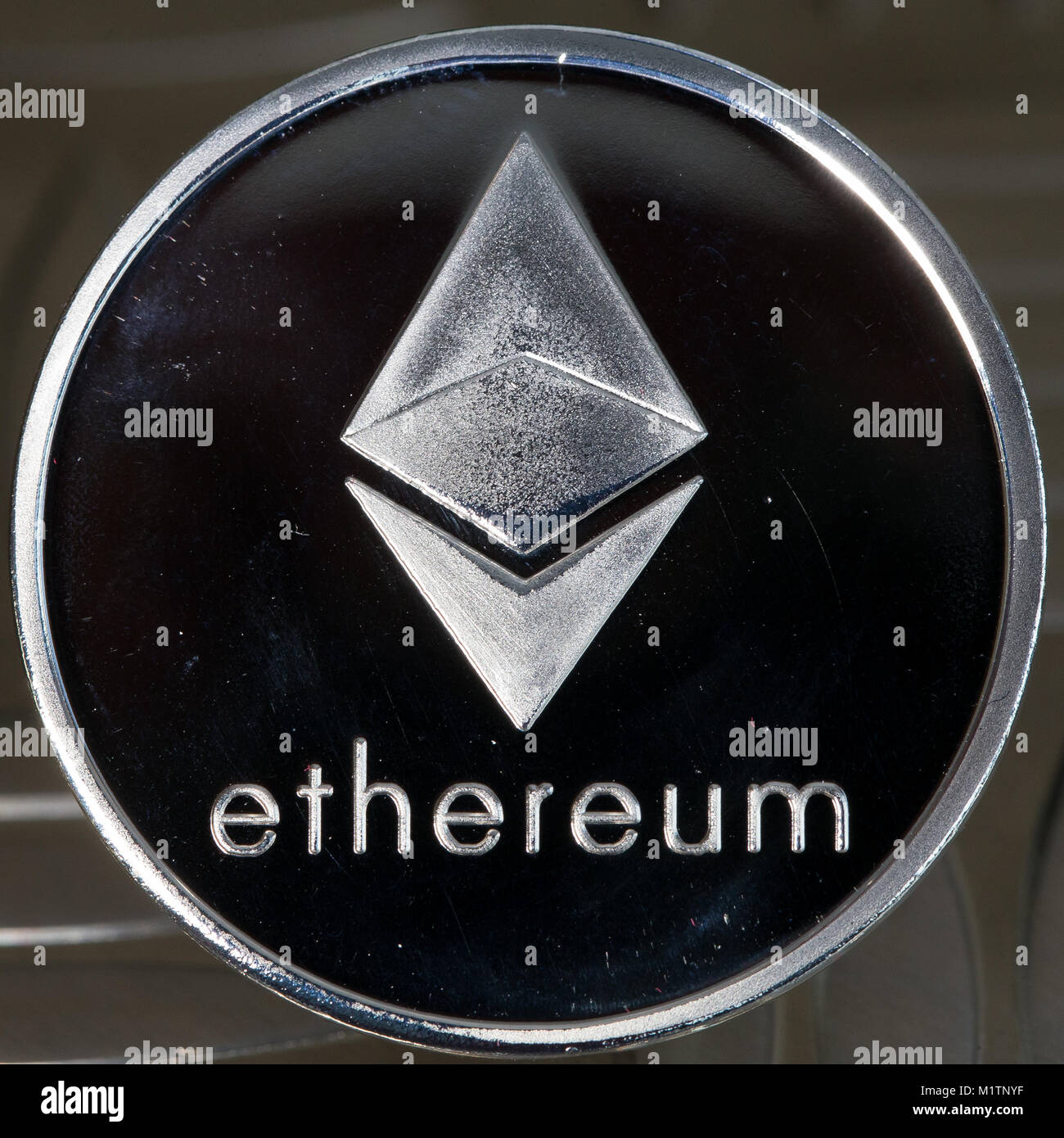 A physical silver Ethereum (ETH) crypto coin token on aluminium chequer ...
