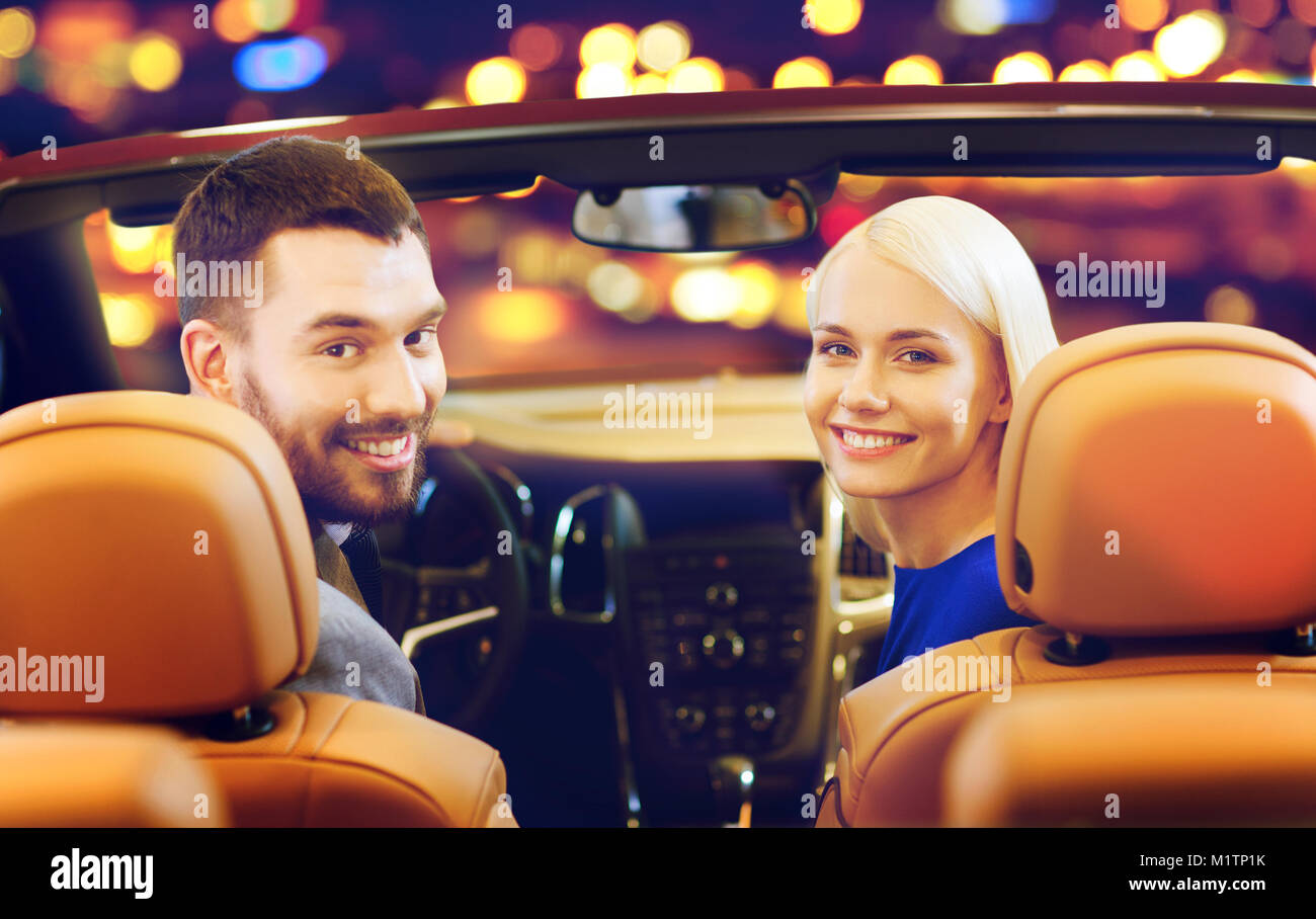 happy couple sitting in car at auto show or salon Stock Photo - Alamy