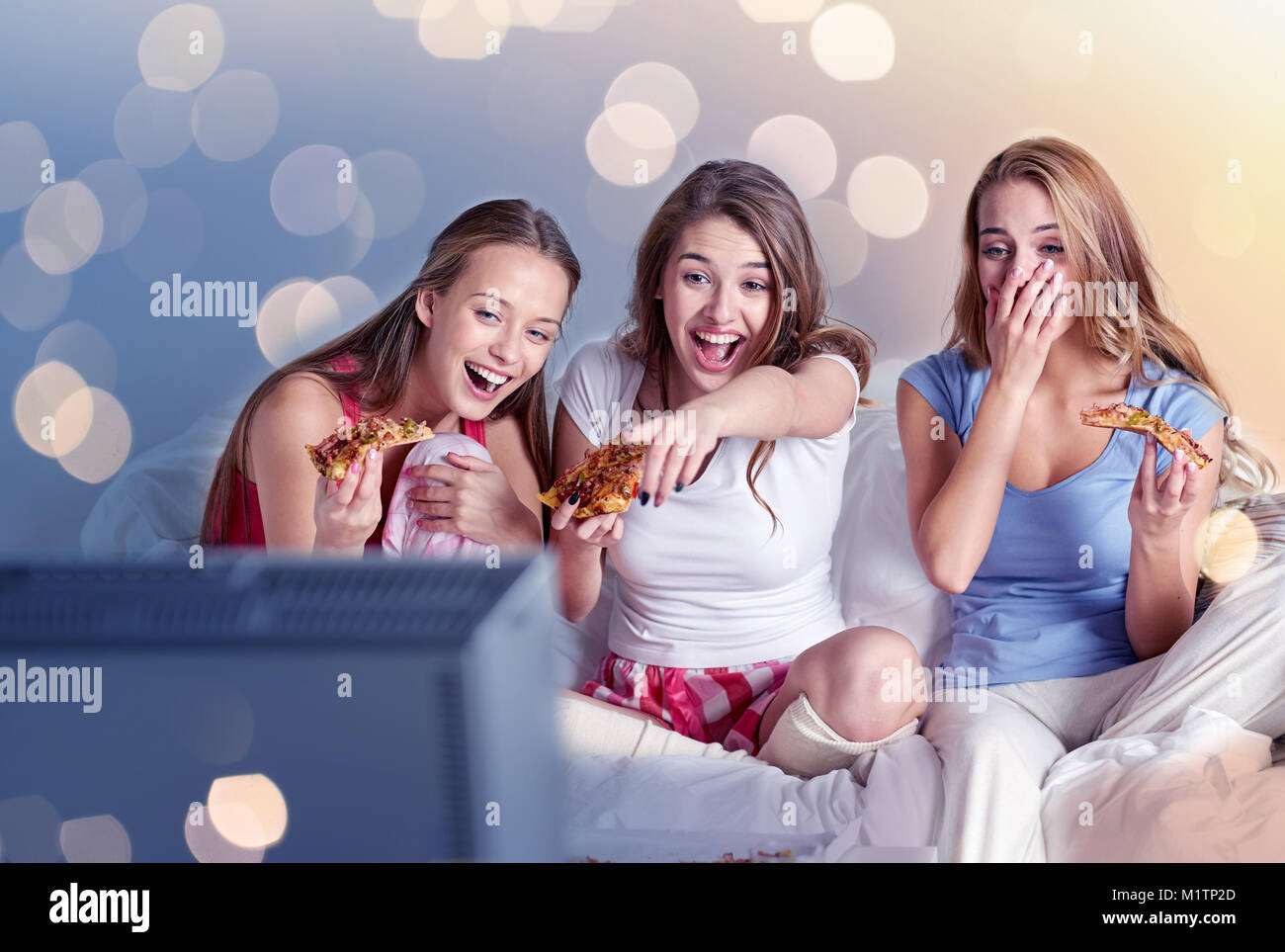 happy friends eating pizza and watching tv at home Stock Photo - Alamy
