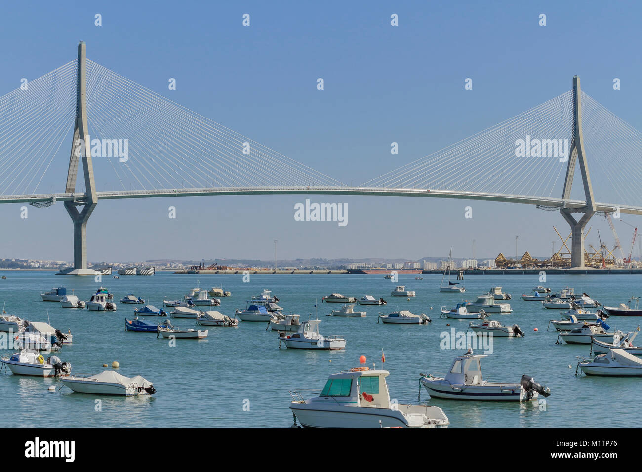 horizontal view of boats at cadiz harbor with the bridge of the ...