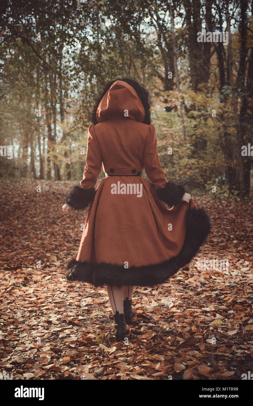 Back view of woman in vintage red coat in autumn leaves Stock Photo - Alamy