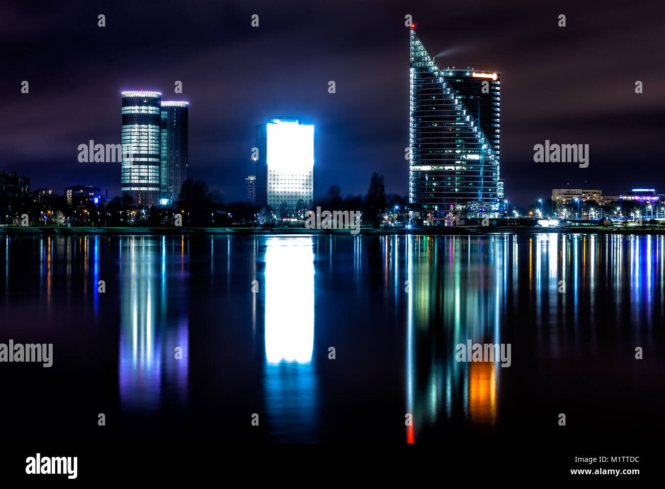 Riga skyline with some skyscrapers. Night shot with scenic water ...