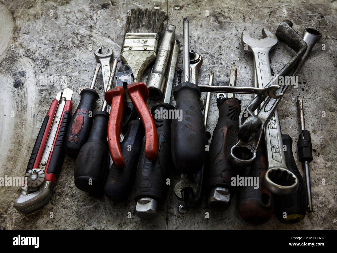 An untidy workbench full of greasy old tools set for repairing or ...