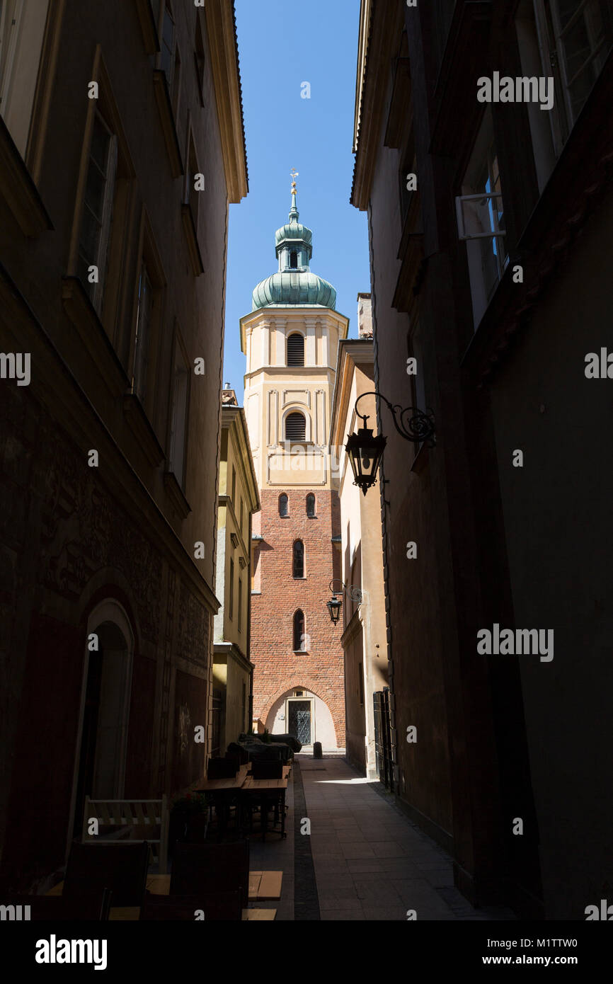 Narrow street and St. Martin church bell tower in Warsaw Old Town ...