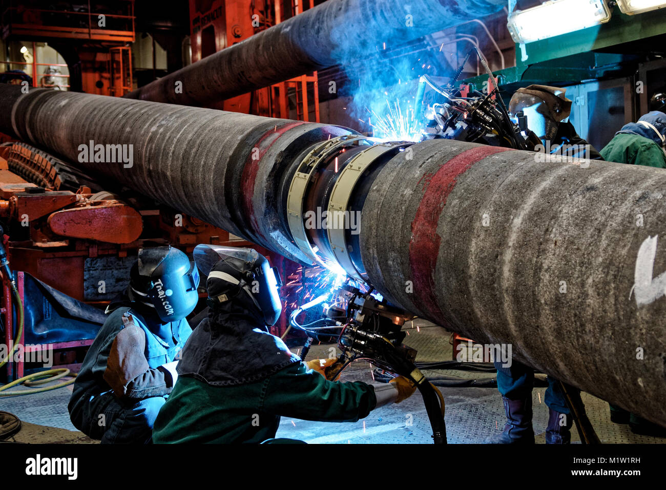 Workers welding sections of a submarine pipeline system using automatic ...