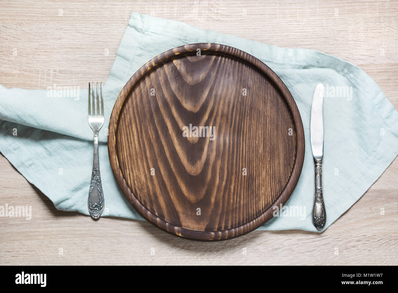 Rustic table set with wooden plate and napkins on wooden table-top. Top ...