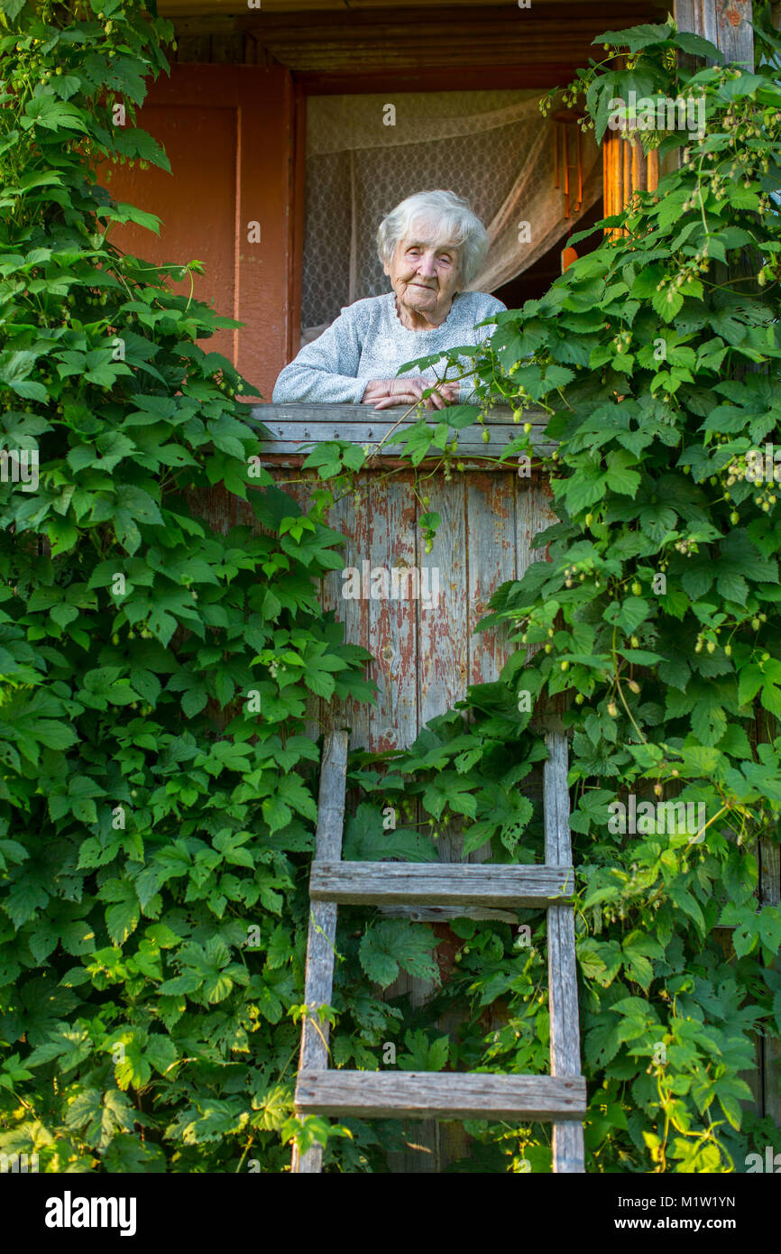 Elderly woman on a green terrace in his rural house Stock Photo - Alamy
