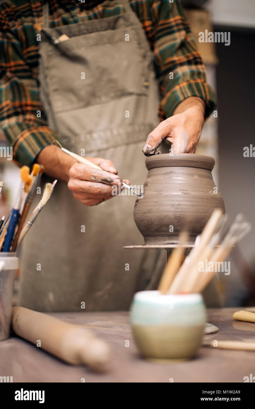 Young man making and decorating pottery in workshop Stock Photo - Alamy