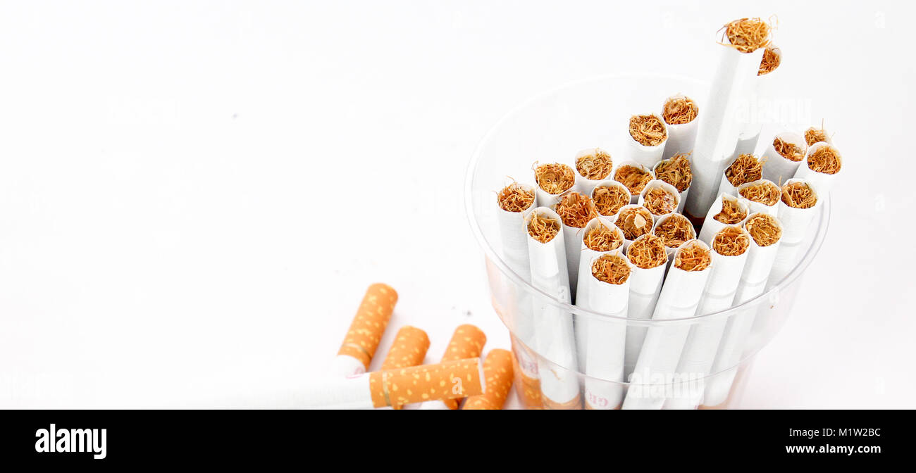 cigarettes in a disposable cup and vintage clock on white background ...