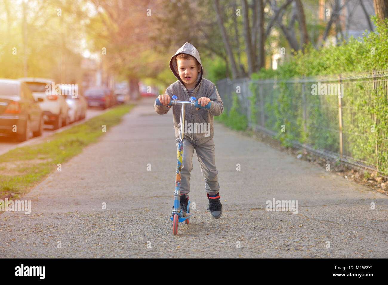 Boy with scooter having fun in the park Stock Photo - Alamy
