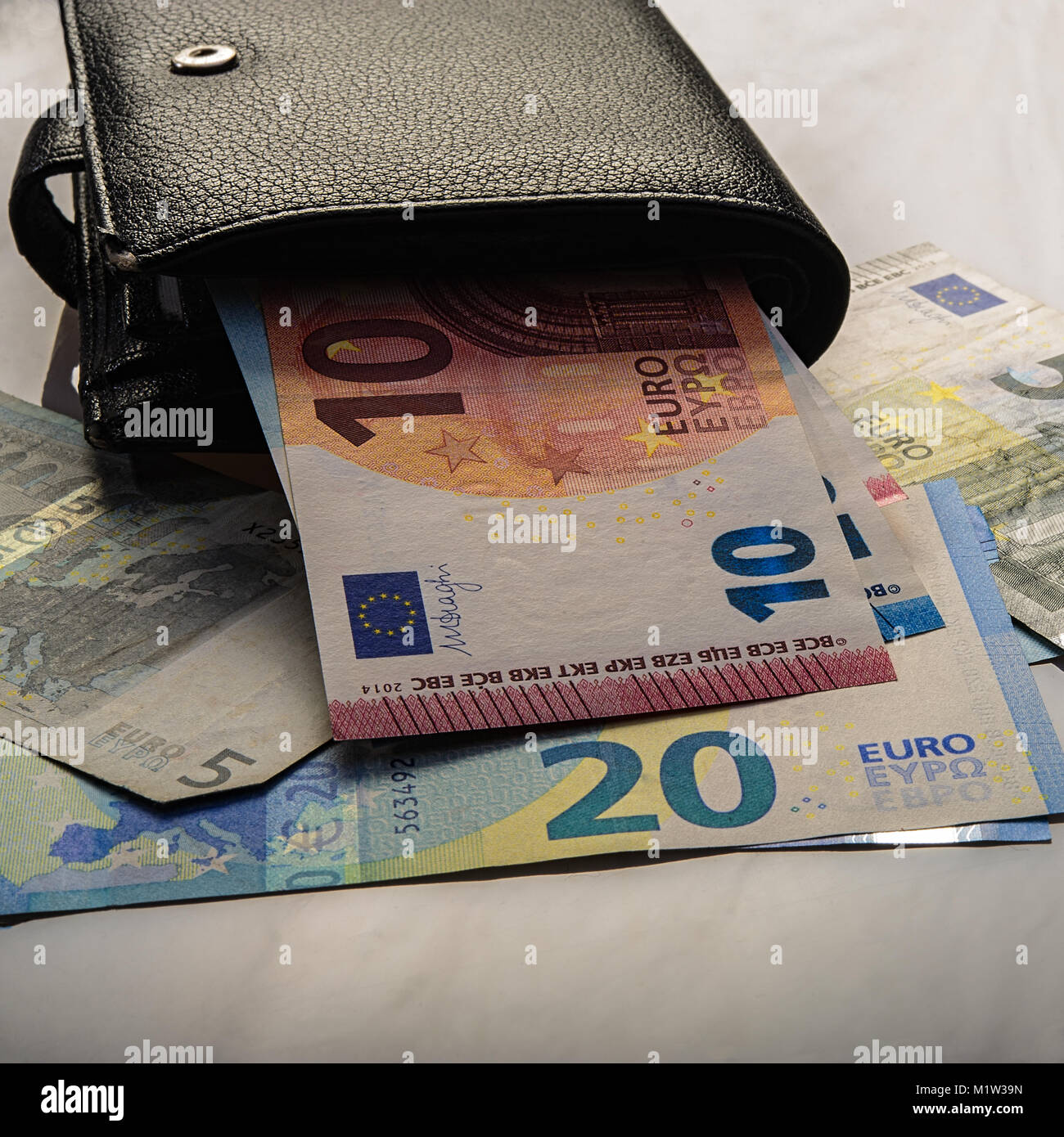 paper euro notes and an old wallet. Five, twenty and ten euros ...