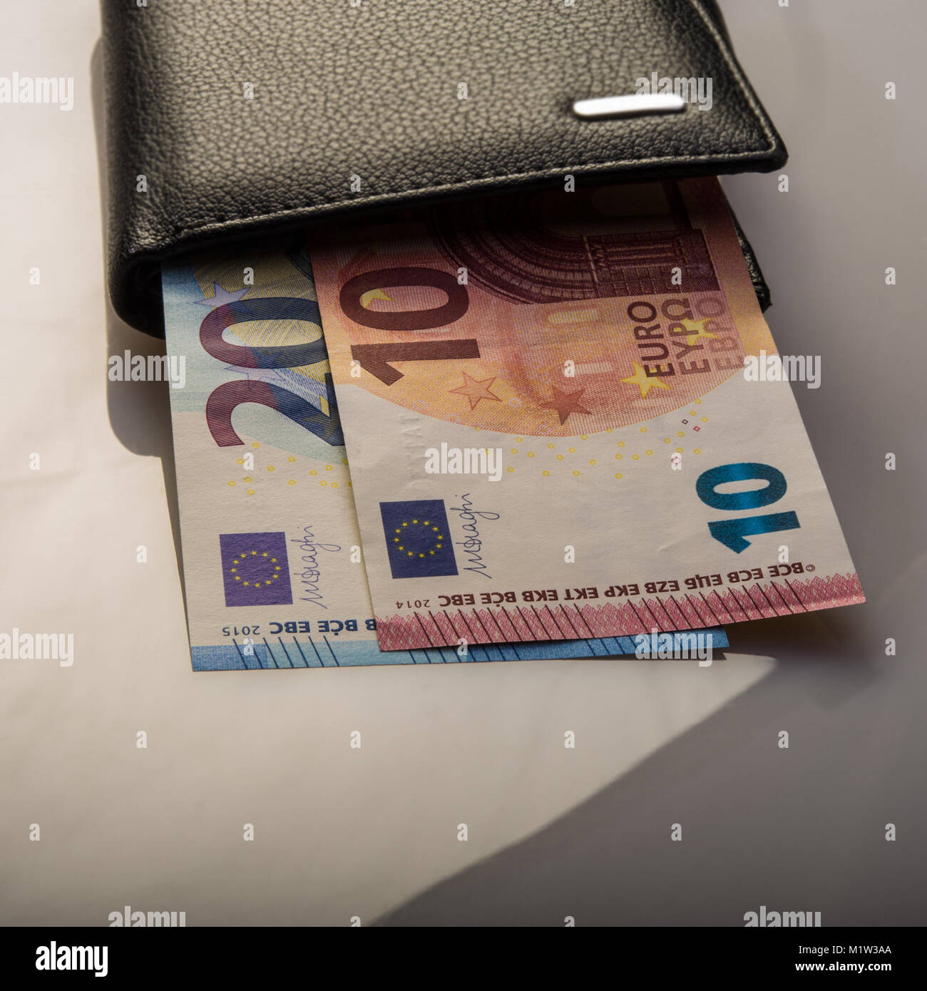 paper euro notes and an old wallet. Twenty and ten euros. Currency of ...