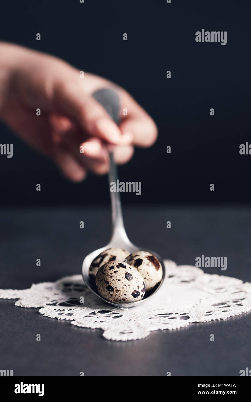 Human hand holding vintage spoons with quail eggs Stock Photo - Alamy