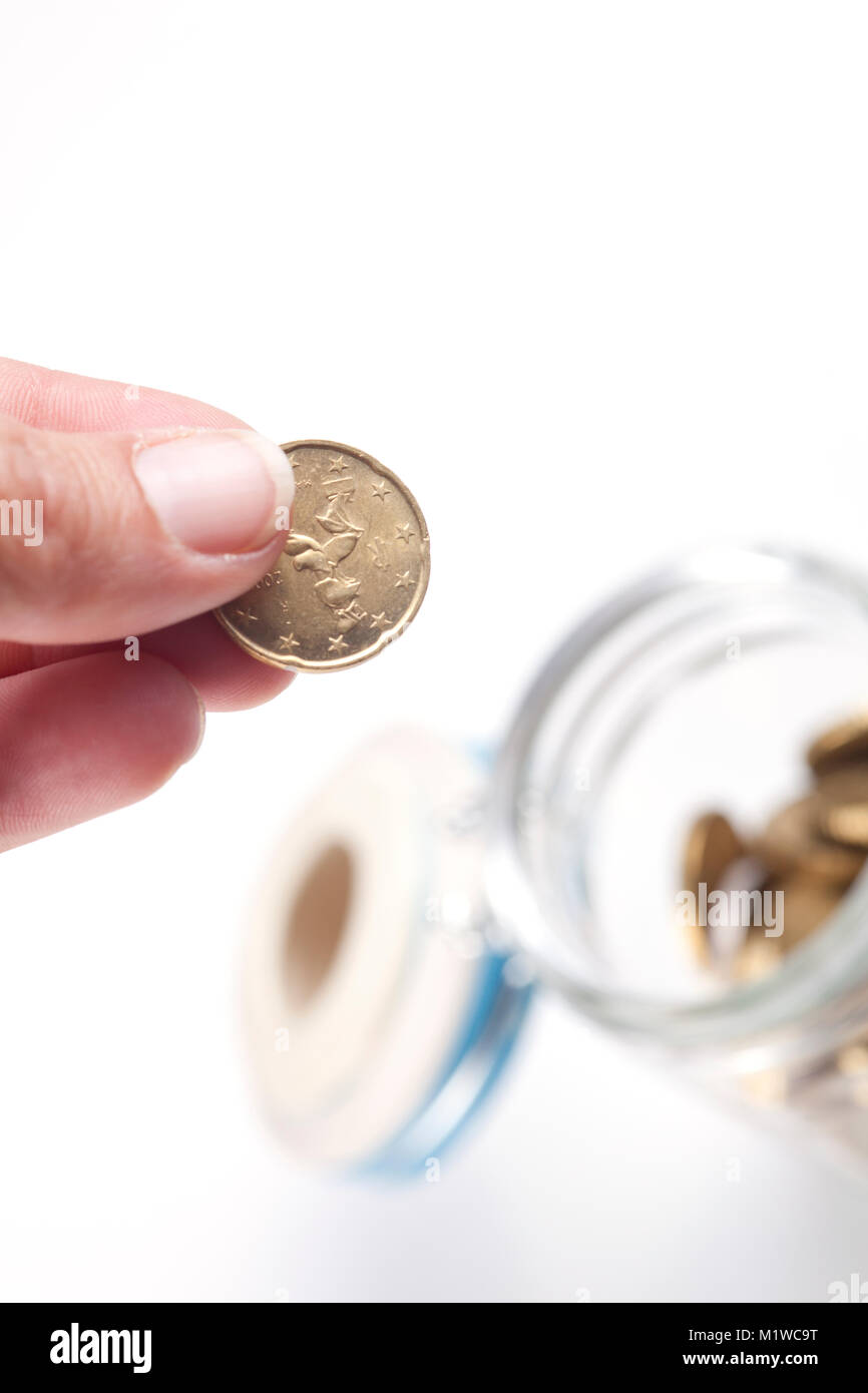 Introducing a coin into an open jar Stock Photo - Alamy