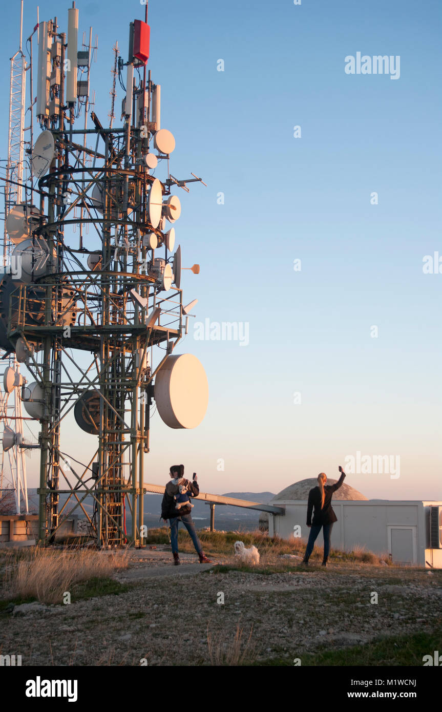 Two girls searching for signal on the hill next to the antenna Stock ...