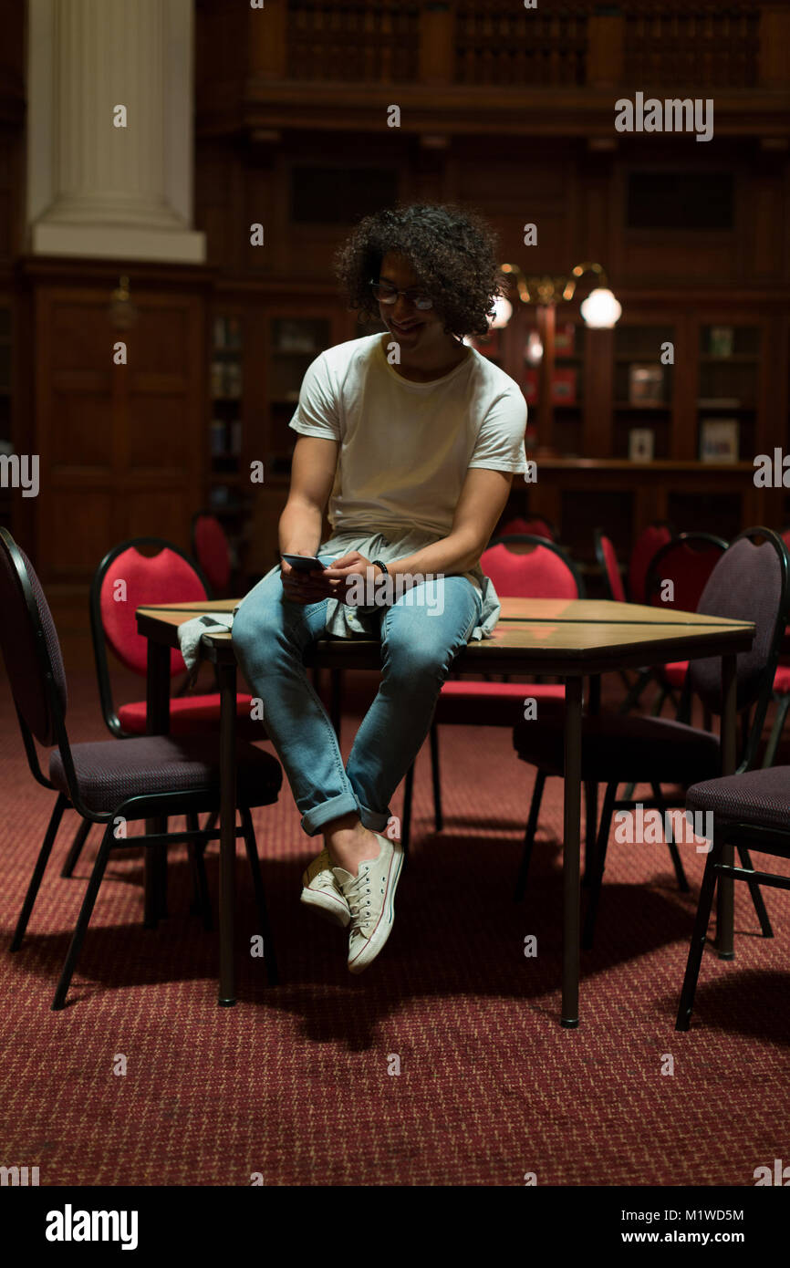 Man using mobile phone in library Stock Photo - Alamy