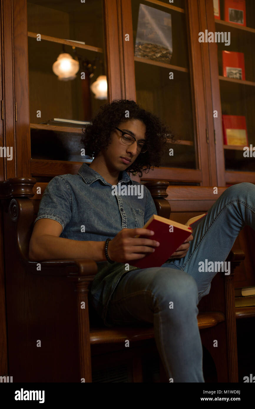 Man reading a book in library Stock Photo - Alamy