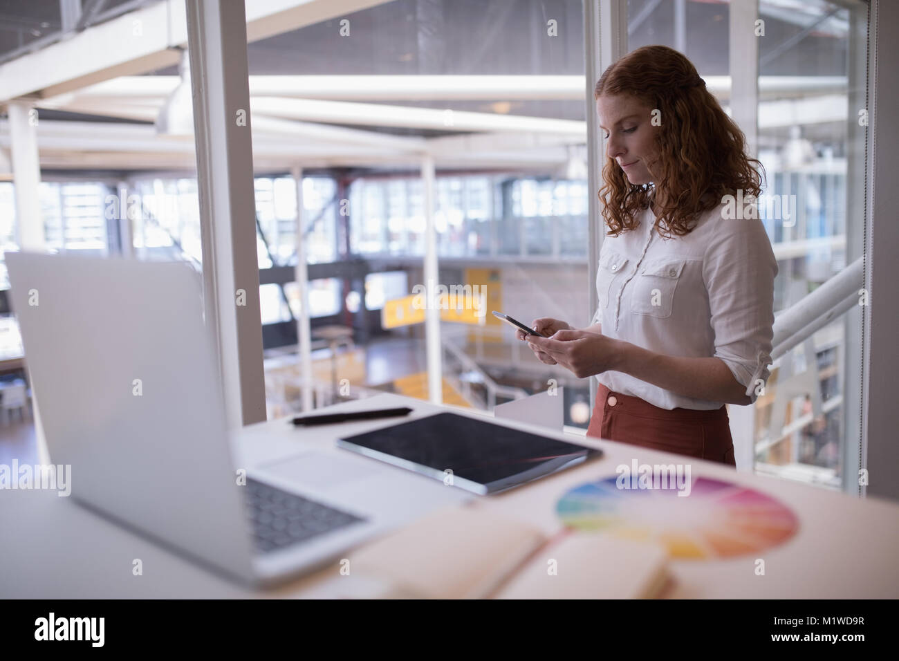 Female graphic designer using mobile phone Stock Photo - Alamy