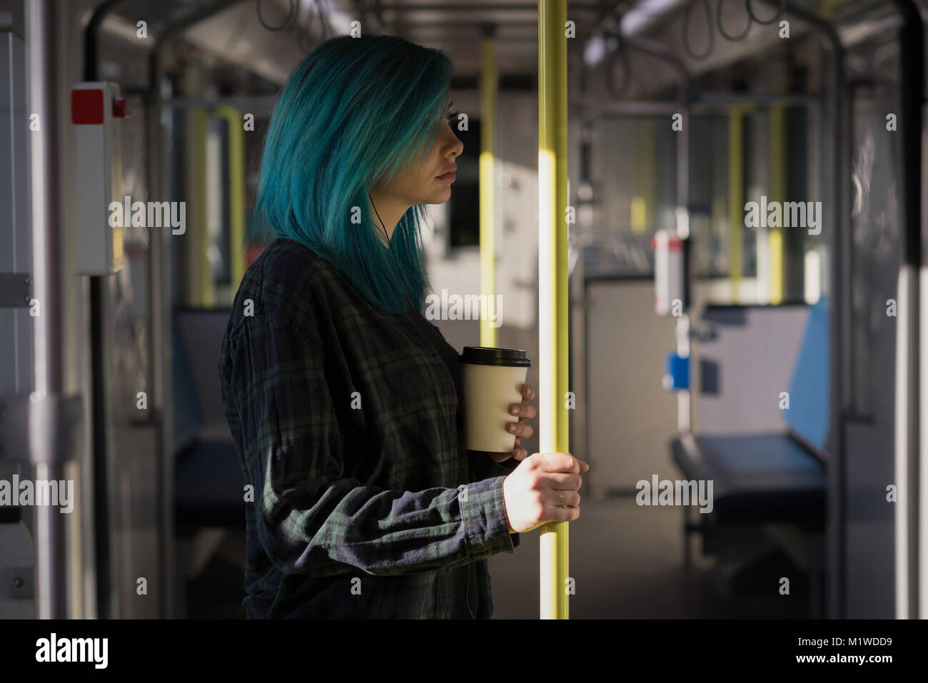 Woman holding coffee cup while travelling in train Stock Photo - Alamy