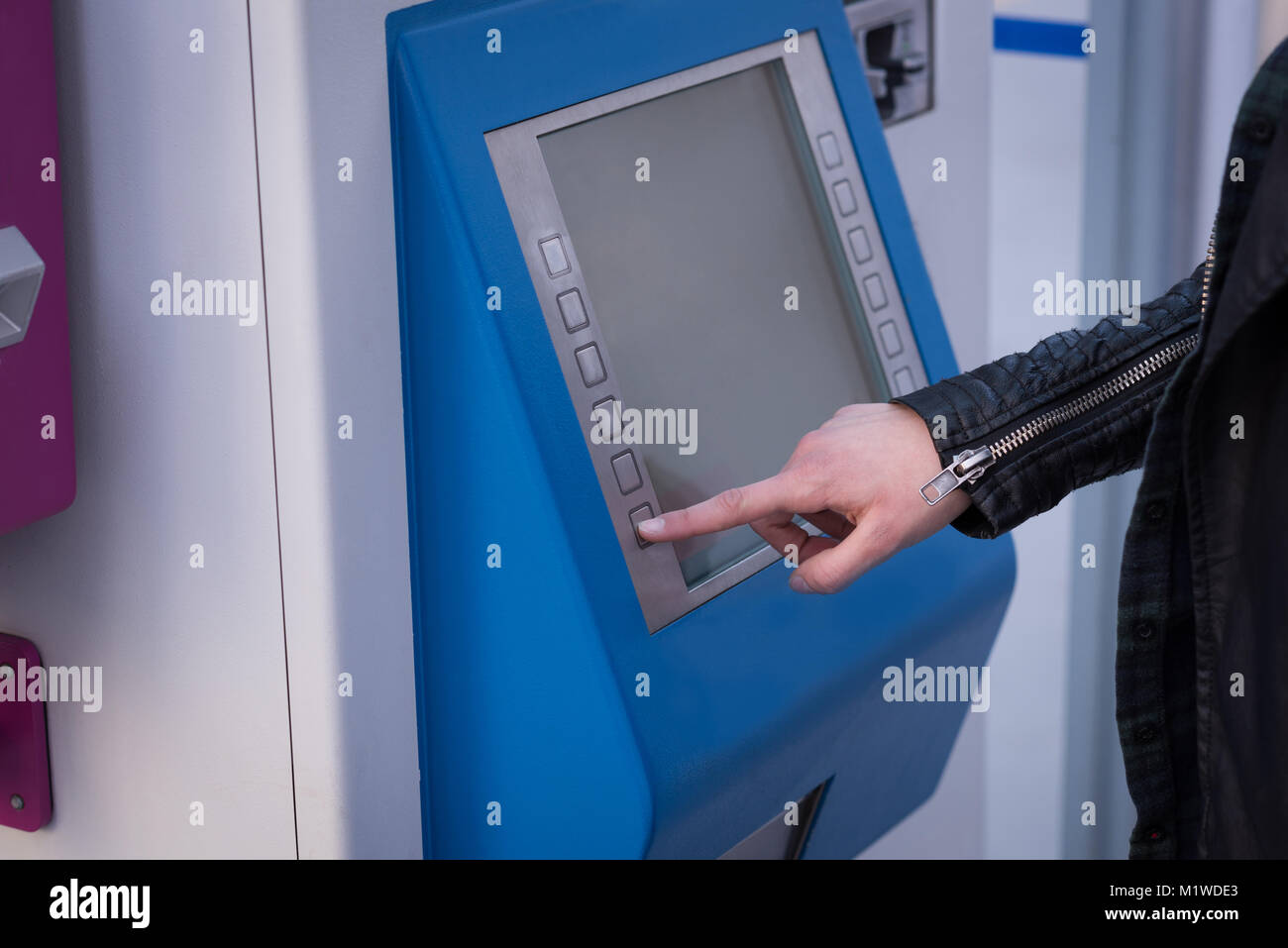 Woman using ticket vending machine at station Stock Photo - Alamy