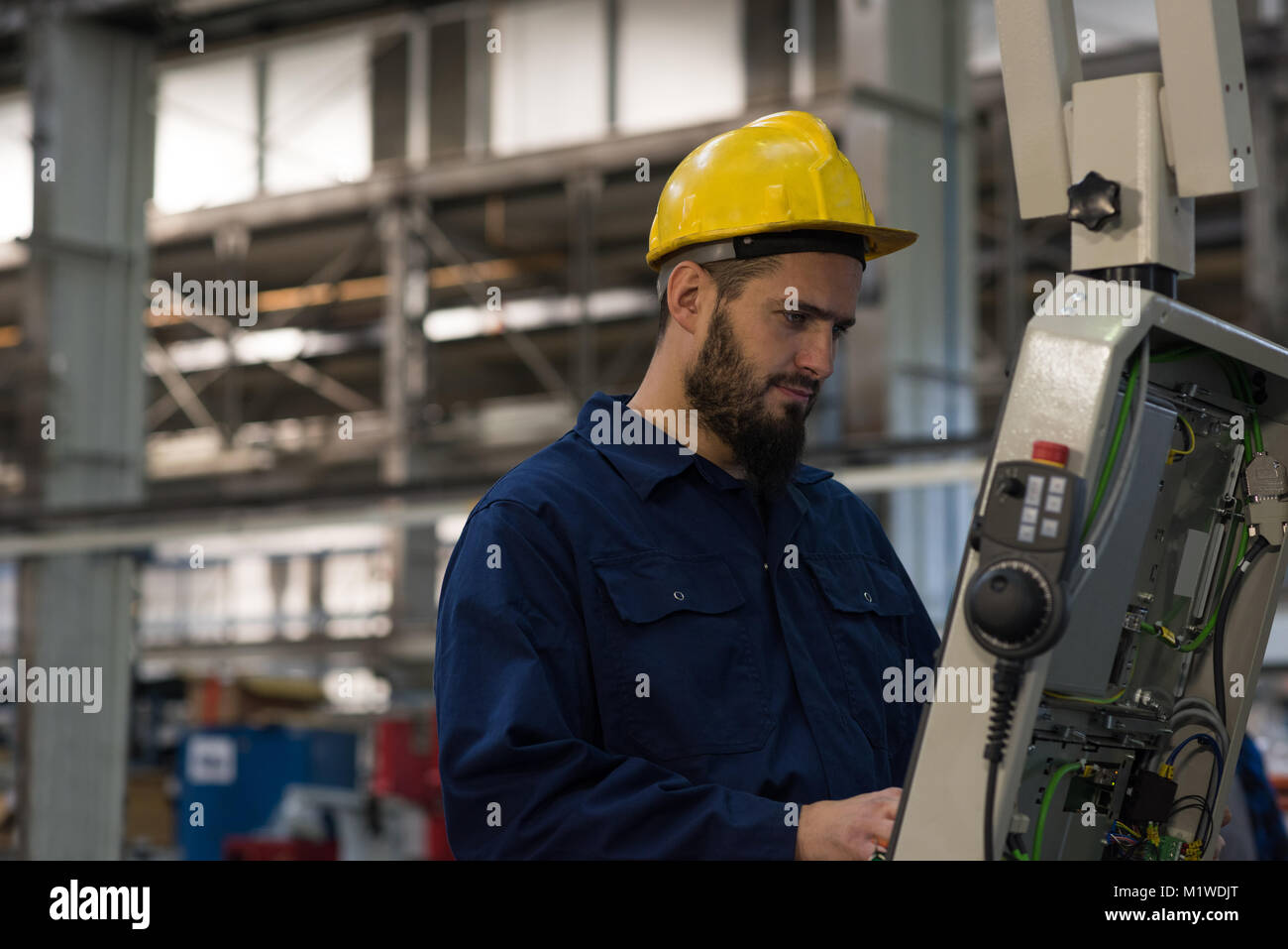Technician operating machine in metal industry Stock Photo - Alamy