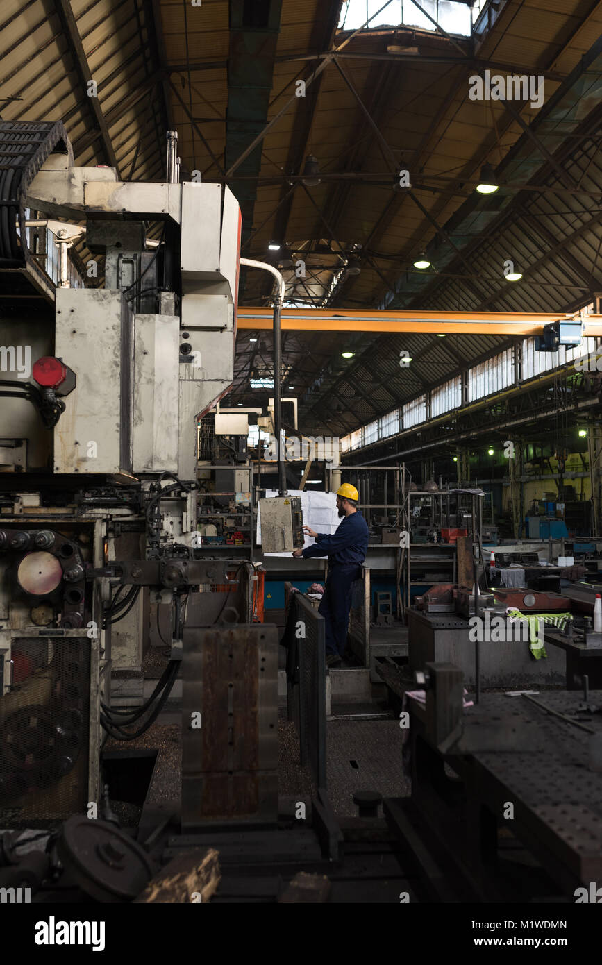 Technician operating machine in metal industry Stock Photo - Alamy