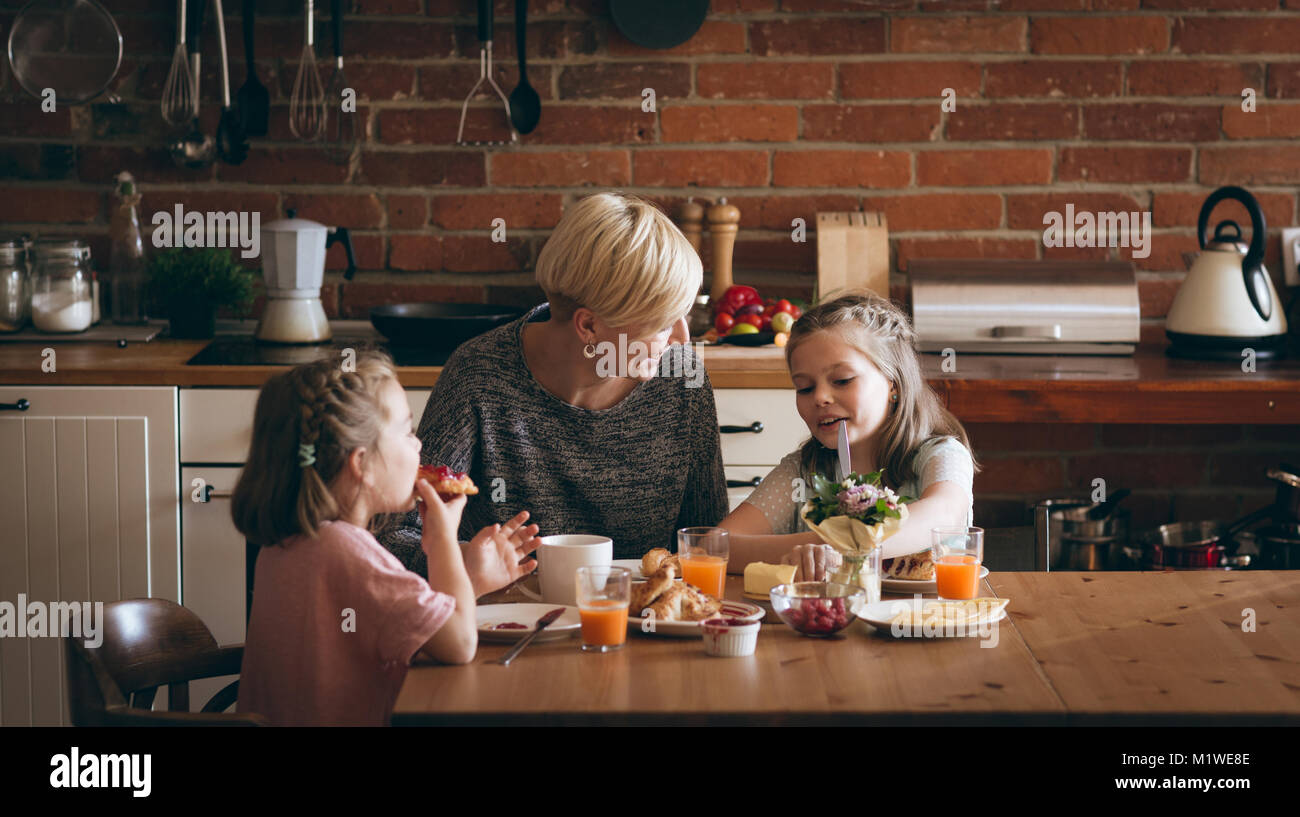 Mother and kids having breakfast at table Stock Photo - Alamy
