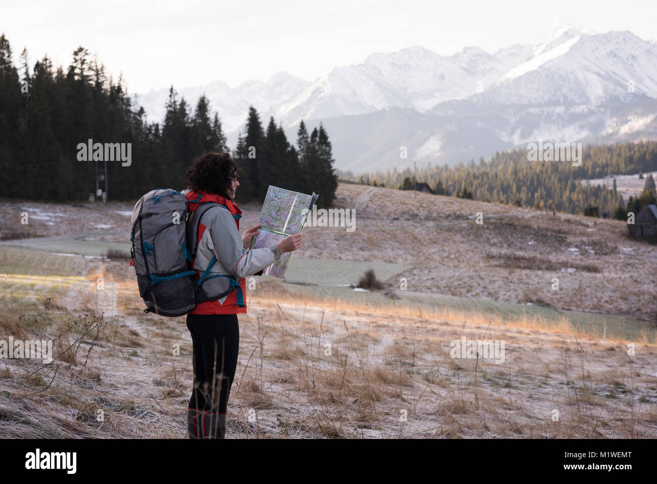 Woman looking at map while hiking Stock Photo - Alamy