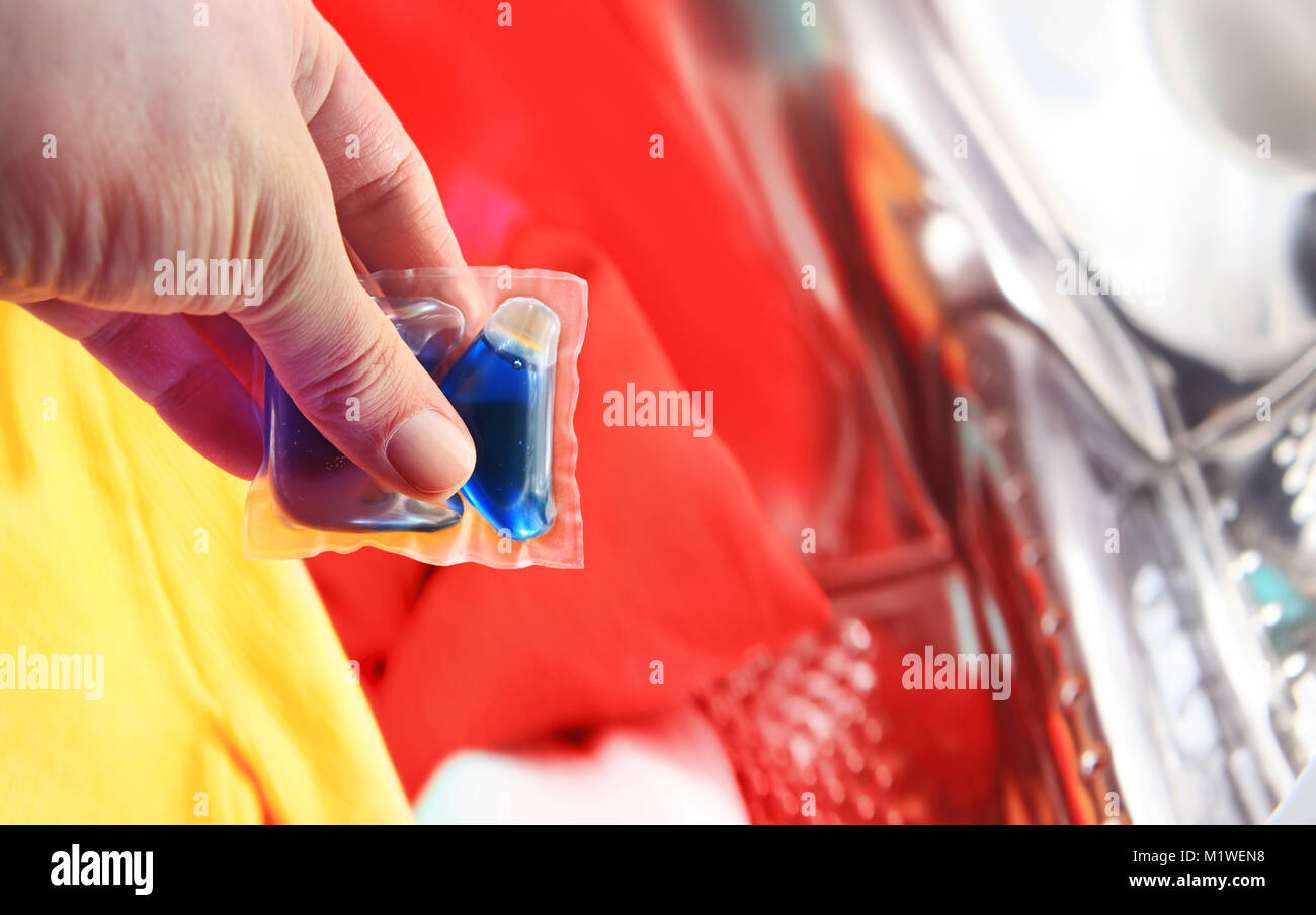 blue gel caps in hand for washing mashine, liquid coloured detergent ...