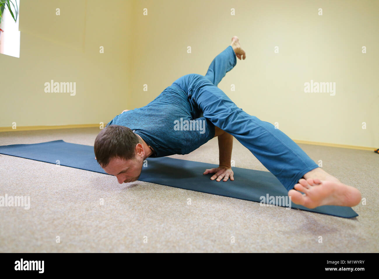 Man of European appearance sits on floor and performs cross twin Stock ...