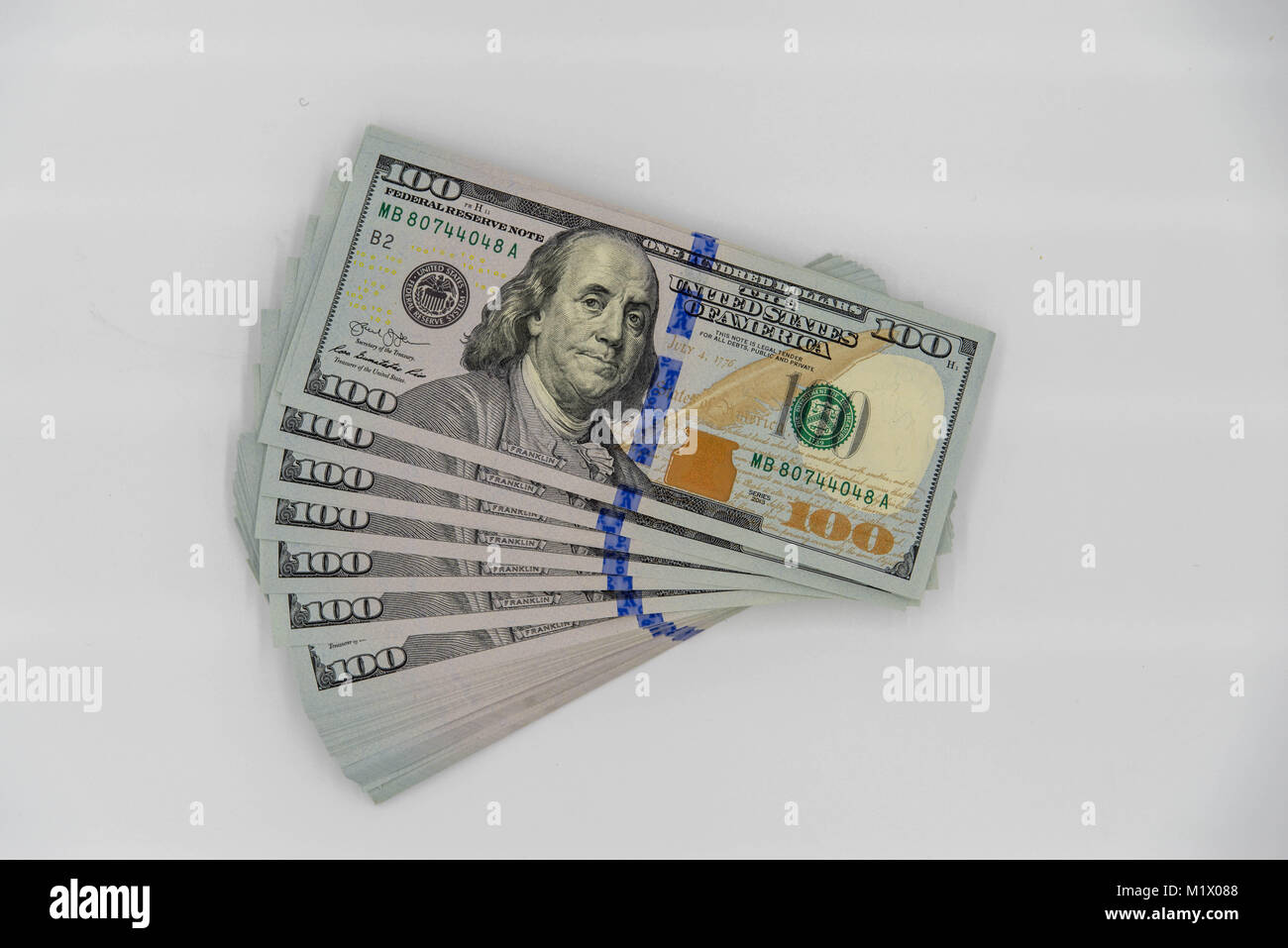 a stack of us 100 dollars cash with white background Stock Photo - Alamy